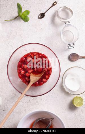 Strawberry jam cooking process. Wooden spoon liying on jam surface ...