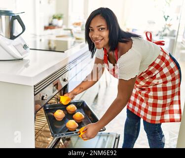 Woman putting dough for muffins into tray on dark background Stock ...