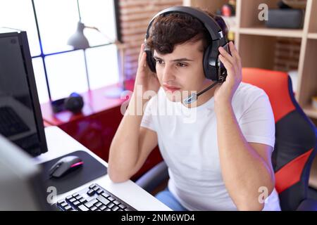 Non binary man streamer sitting on table with relaxed expression at ...