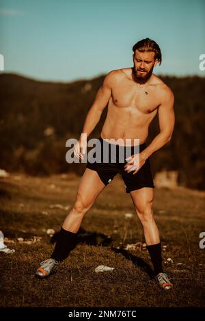 A man stretching after a hard workout in the early hours of the morning ...