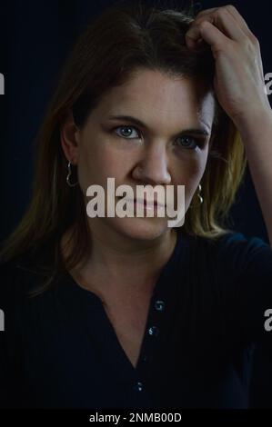 portrait of a beautiful blonde woman scratching her head in concern ...