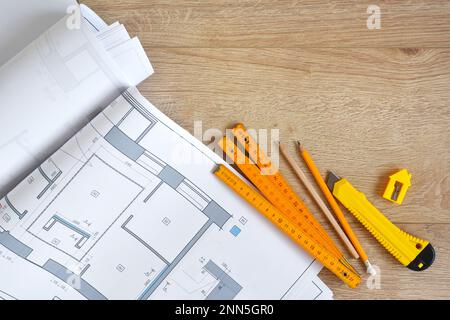 Architectural drawings and pencils, ruler, clerical knife on wooden ...