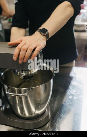 Making macarons. A silver kitchen table mixer kneads the dough for ...