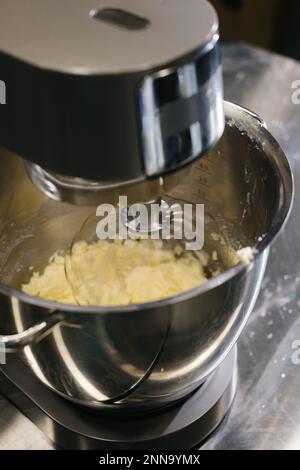 Making macarons. A silver kitchen table mixer kneads the dough for ...