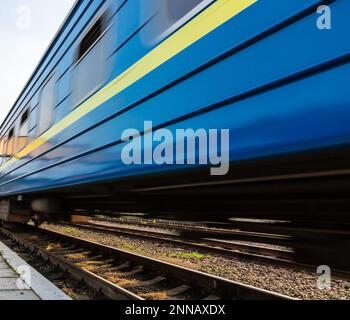 a blue passenger train travels along the track Stock Photo - Alamy