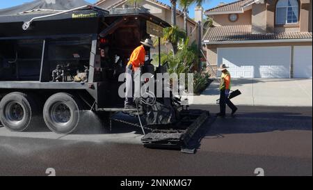 Vista, CA USA - February 6 2023: A crew of workers applies slurry seal ...
