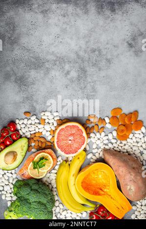 Vegetables, fruit and foods containing potassium over gray stone ...