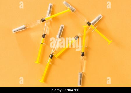 Elevated view medical syringes yellow background Stock Photo - Alamy