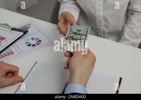Cashier giving money to businesswoman at desk in bank, closeup Stock ...