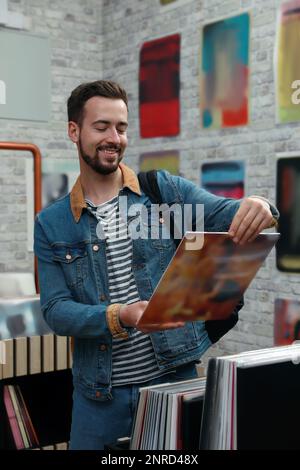 Happy man choosing vinyl record to play with turntable at home Stock ...