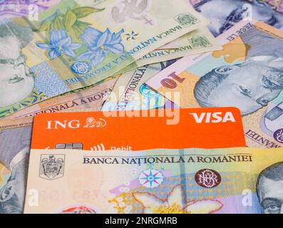 ING debit card and many romanian banknotes on black background ...