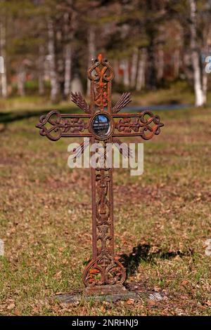 A closeup of an ancient metal Cemetery cross against a stone wall Stock ...