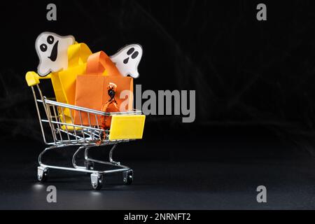 A small cart with bags, gifts and ghosts on the black background ...