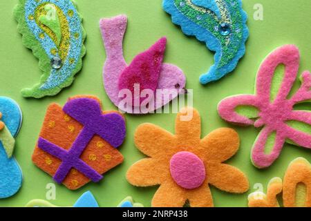 Different small colorful felt items on green background, flat lay Stock ...