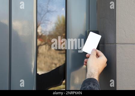 Man opening magnetic door lock with key card, closeup. Home security ...