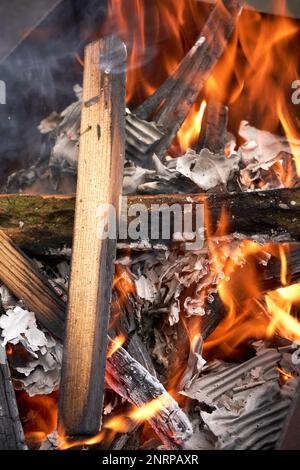 Wooden sticks and ashes from burnt paper engulfed in fire, burning ...