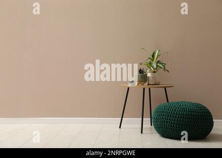 Knitted pouf near beige wall Stock Photo - Alamy