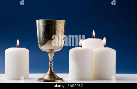 beautiful christian chalice surrounded by candles and blue background ...