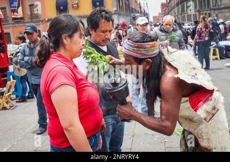 Mexican shaman performing a cleansing ceremony on a woman in the Zocalo ...