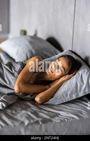 Sleepy female keeping eyes closed while dreaming about future vacation ...