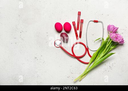 Stethoscope with test tubes, Easter eggs and flowers on light ...