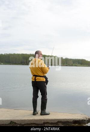 Russian modern male fisherman fishes on an ultralight spinning rod in ...