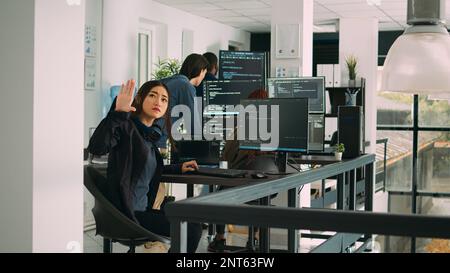 Asian web developer working with hologram and coding language in programming software company ...