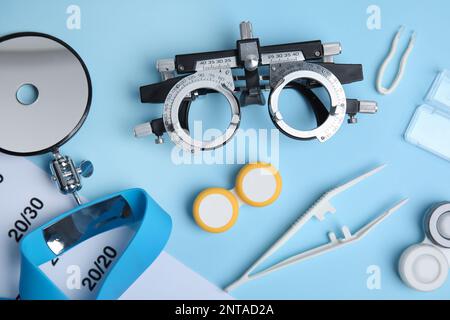 Different ophthalmologist tools on light blue background, flat lay ...