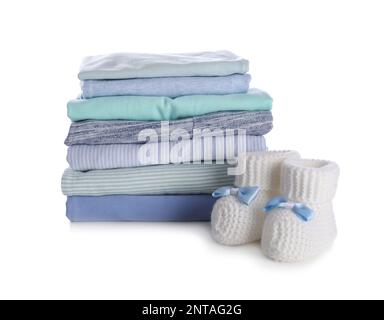 Stack of clean baby's clothes and small booties on bed Stock Photo - Alamy