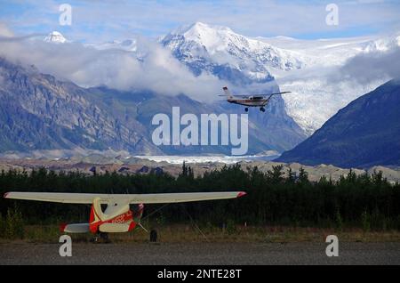 Two small bush planes in front of huge glaciers, national park ...