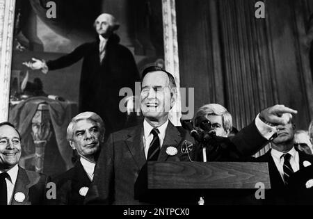 President George H.W. Bush pointing to a tabloid newspaper with Ross ...