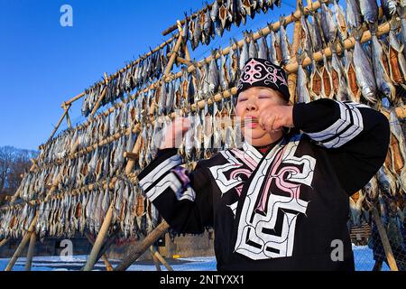 Ainu woman playing a traditional instrument in Ainu village museum ...