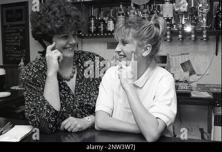 Late 1980s, historical, two female employees working at desks in a ...