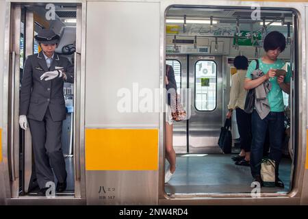Train conductor and passengers. Shinjuku Railway station.Chuo Sobu Line ...