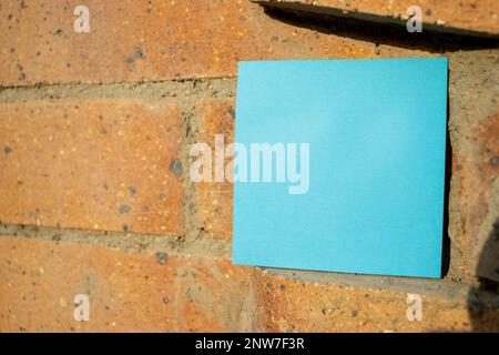 blue square paper note resting on old peeling white paint with empty ...