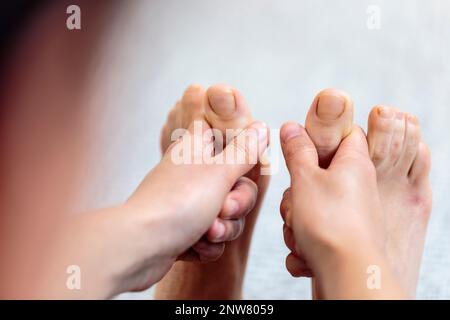 Yogini doing forward bending exercise on the floor, reaching foot and ...