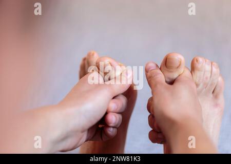 Yogini doing forward bending exercise on the floor, reaching foot and ...