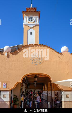 The Moorish-style clock tower rises over the ochre arches and red-tiled ...