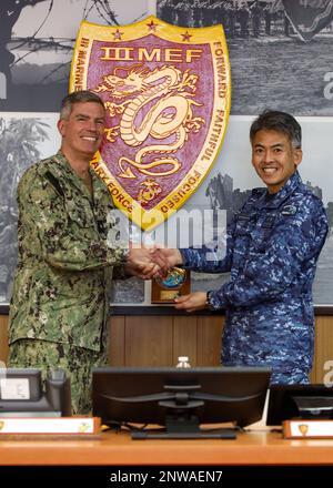 U.S. Navy Rear Adm. Derek Trinque, commander, Task Force 76/3, left ...