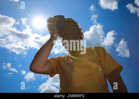 Senior man with cold pack suffering from heat stroke outdoors, low ...