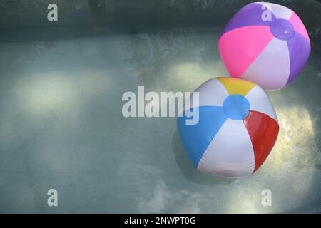 Two inflated beach balls floating in a stock tank pool. A refreshing ...