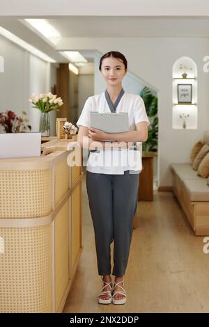 Portrait of young cheerful positive smiling woman client with magazine ...