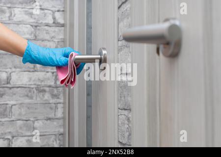 man wiping a doorknob with a rag. wet house cleaning Stock Photo - Alamy