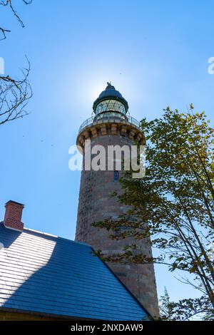 Lodbjerg Fyr from afar between trees with blue sky, Denmark Stock Photo ...
