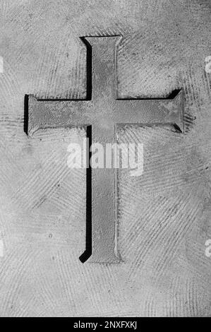 A simple typical cross embossed on a copper metal wall in a black and ...
