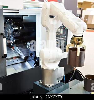Universal industrial robotic arm and cnc lathe machine Stock Photo - Alamy