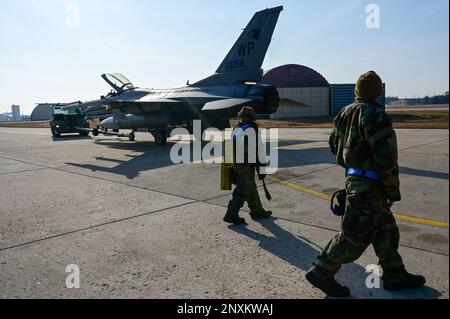 A member of the 80th Fighter Generation Squadron marshals an F-16 ...