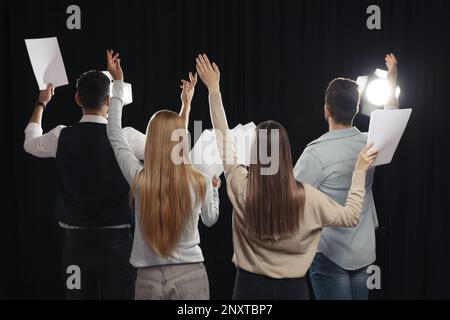 Professional actors bowing on stage in theatre, back view Stock Photo ...