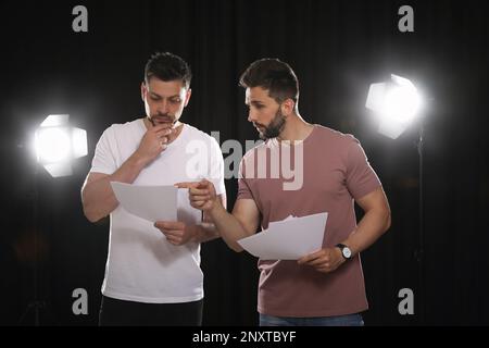 Professional actors reading their scripts during rehearsal in theatre ...