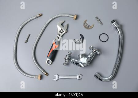 Parts of water tap and wrenches on grey background, flat lay Stock ...